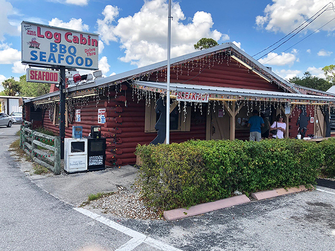 The crimson log cabin exterior isn't trying to be Instagram-worthy—it's been perfecting BBQ long before social media told us what to eat.