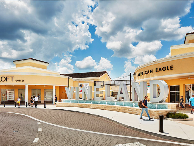 The iconic Vineland sign welcomes shoppers like a retail Statue of Liberty, promising freedom from full retail prices under Florida's endless blue skies.