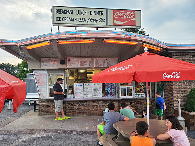The classic mid-century curved roof of Magic Wand beckons like a time machine disguised as a restaurant. Those red Coca-Cola umbrellas aren't just for show—they're portals to simpler times.