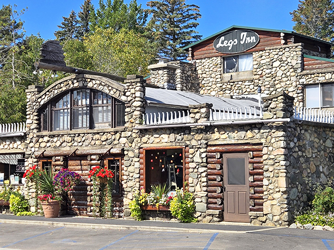 The stone fortress of Legs Inn stands proudly at the end of Michigan's Tunnel of Trees, its quirky roofline adorned with cast iron stove legs that give this culinary landmark its name.