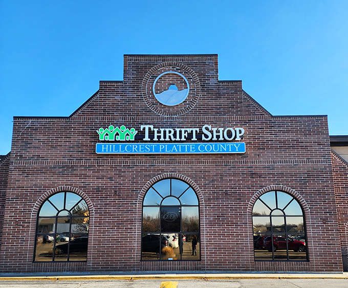 The stately brick facade of Hillcrest Thrift Shop beckons bargain hunters with its distinctive arched windows and warm, inviting glow at sunset.