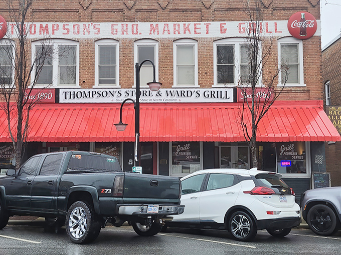 The iconic red awning of Thompson's Store & Ward's Grill beckons hungry travelers like a culinary lighthouse on Saluda's Main Street.