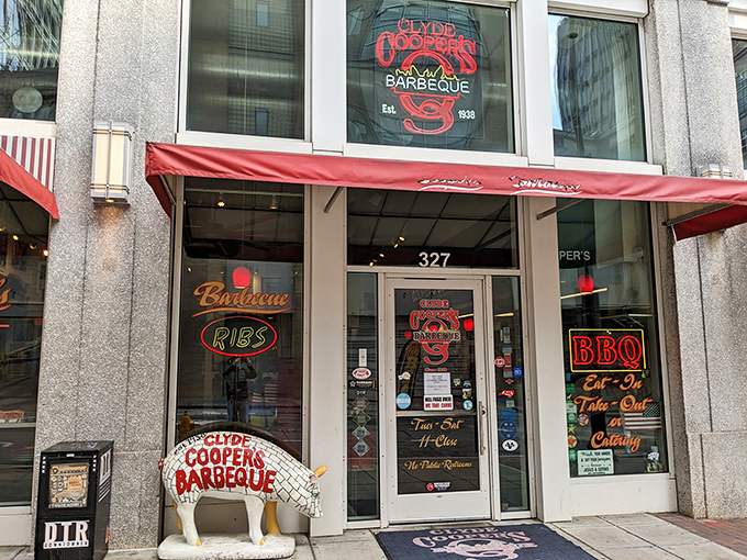 The iconic red-and-white storefront of Clyde Cooper's Barbeque stands as a beacon of hope for hungry souls in downtown Raleigh. That pig statue knows what you're in for.