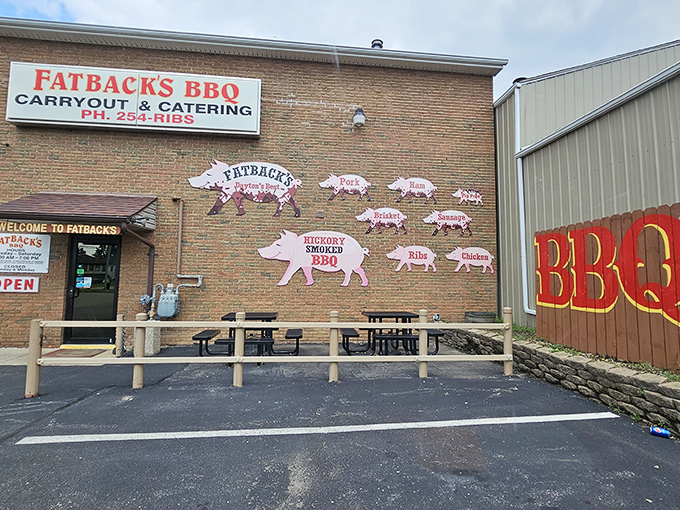 The iconic brick exterior of Fatback's BBQ, where those pig cutouts aren't just decoration&mdash;they're a roadmap to smoky paradise.