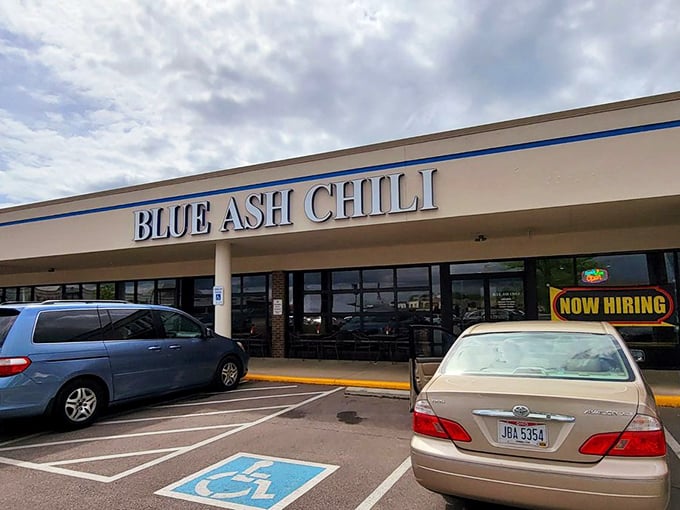 The blue lettering of Blue Ash Chili stands out against the strip mall backdrop like a neon promise of comfort food nirvana ahead.