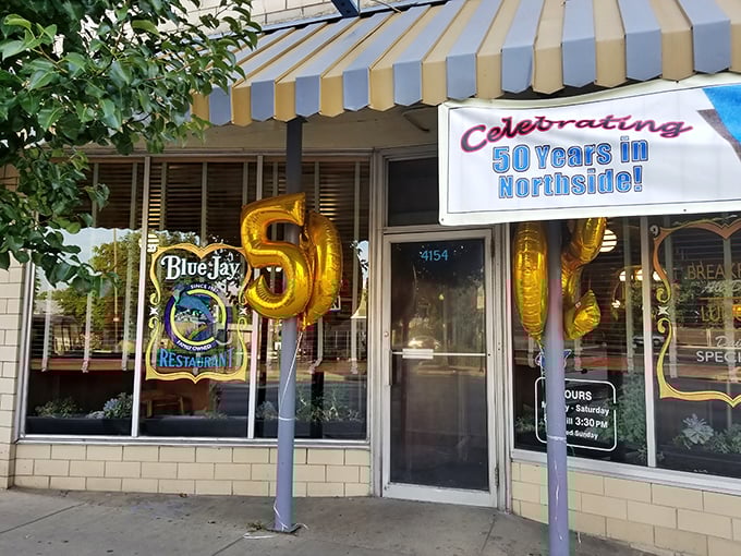 The Blue Jay's iconic striped awning and golden "50 years" balloons aren't just decoration&mdash;they're a promise of Cincinnati breakfast history that's stood the test of time.