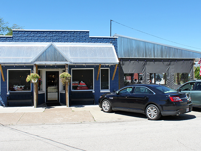 The bright blue exterior of Sparky's Place stands out like a beacon of culinary hope on Conneaut's streetscape, hanging baskets adding a touch of homey charm.