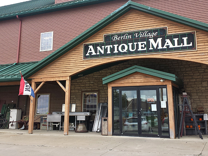 The distinctive barn-red exterior with green roof makes Berlin Village Antique Mall stand out like a treasure chest waiting to be opened.