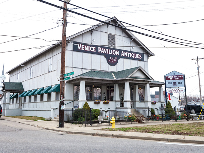 The stately white facade of Venice Pavilion Antiques welcomes treasure hunters with its Civil War-era cannon display and inviting front porch.