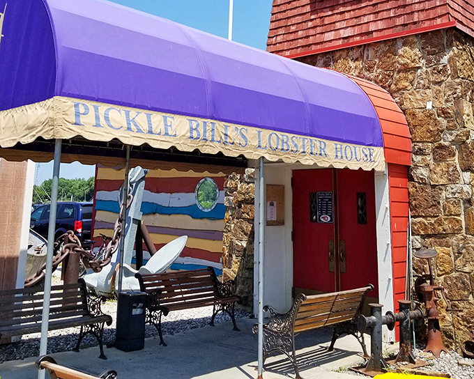 The iconic purple awning of Pickle Bill's stands out like a maritime beacon, promising seafood treasures within those stone walls.