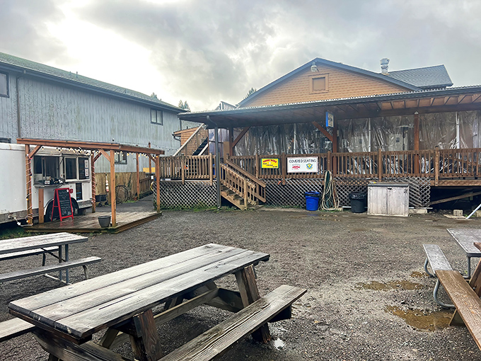 The unassuming exterior of Riverside Fish n' Chips beckons with its rustic charm, red umbrella, and promise of seafood treasures waiting to be discovered.