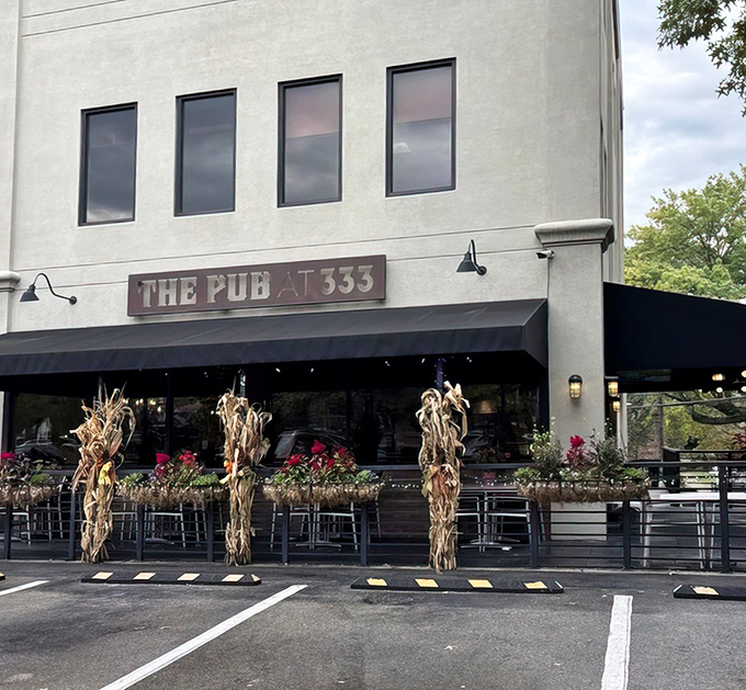 The welcoming facade of The Pub at 333 in Oakmont, with seasonal corn stalks and flowers creating that "come on in" vibe every neighborhood gem should have.