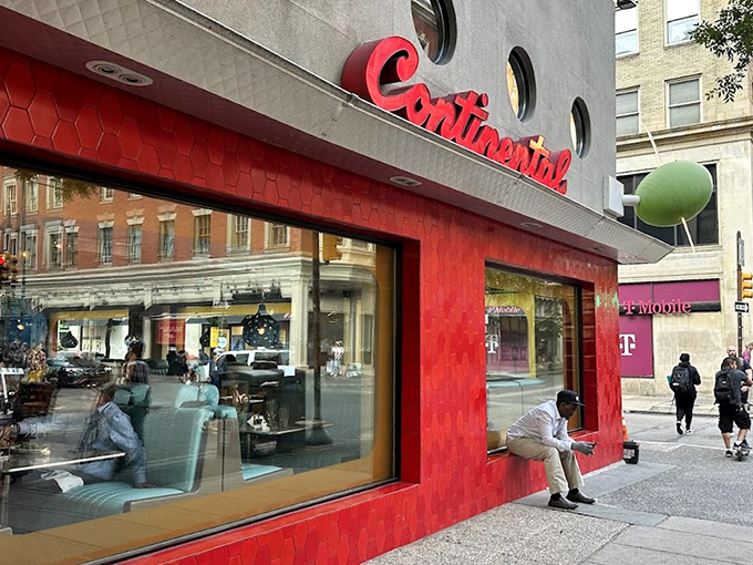 The Continental's iconic red fa&ccedil;ade with porthole windows stands like a retro spaceship that landed in Rittenhouse Square, promising culinary adventures within.