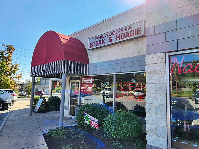 The iconic red awning beckons like a culinary lighthouse, promising authentic Philadelphia flavors in the heart of Camp Hill.