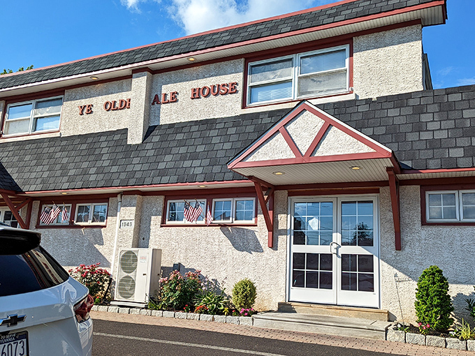 The unassuming exterior of Ye Olde Ale House stands like a culinary speakeasy—no flash, all substance. American flags flutter gently, promising patriotism with your pot roast.