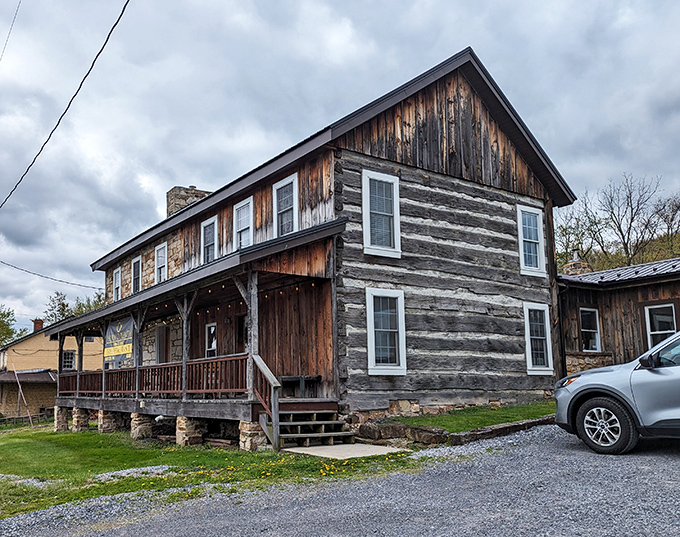 This weathered log cabin exterior whispers promises of comfort food adventures waiting just beyond those rustic doors.