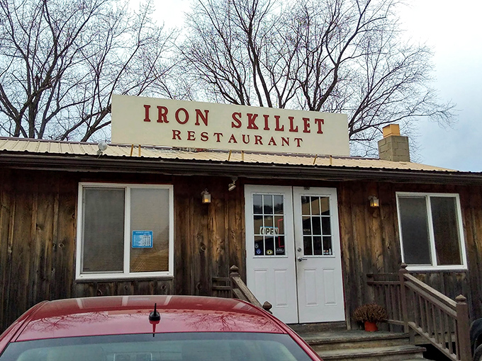 The unassuming wooden exterior of Iron Skillet stands like a culinary time capsule in Troy, promising comfort food treasures for those wise enough to stop.