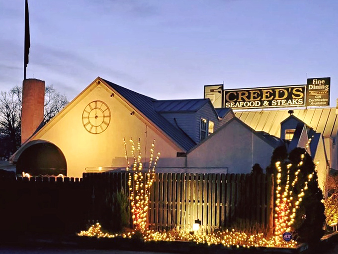 Twilight transforms Creed's into a glowing beacon of culinary promise, its distinctive clock face and twinkling lights beckoning hungry travelers like a gastronomic lighthouse.