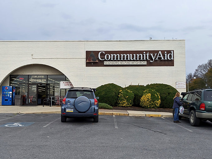 The white-brick facade of CommunityAid stands like a beacon of bargain possibilities, its "Neighbors Helping Neighbors" motto promising treasures and good karma in equal measure.