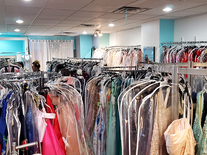 A rainbow of formal wear awaits, each gown protected like a celebrity before the red carpet. Fashion dreams in plastic cocoons.