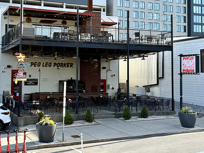 The neon pig sign glows like a beacon of barbecue hope in Nashville's Gulch neighborhood, promising smoky delights within these unassuming walls.