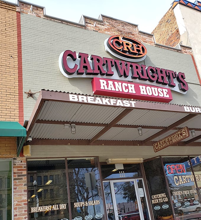 The iconic Cartwright's Ranch House sign stands proudly against the Texas sky, a beacon for hungry souls seeking comfort food salvation.