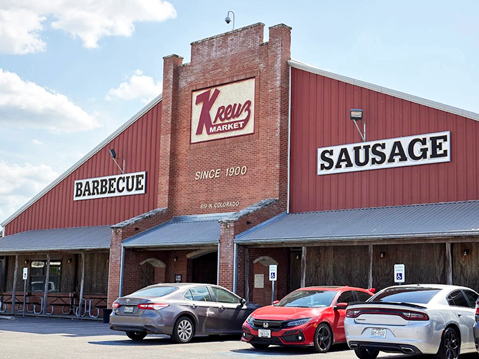 The iconic Kreuz Market stands like a barbecue cathedral against the Texas night sky, its red sign a beacon calling hungry pilgrims home.