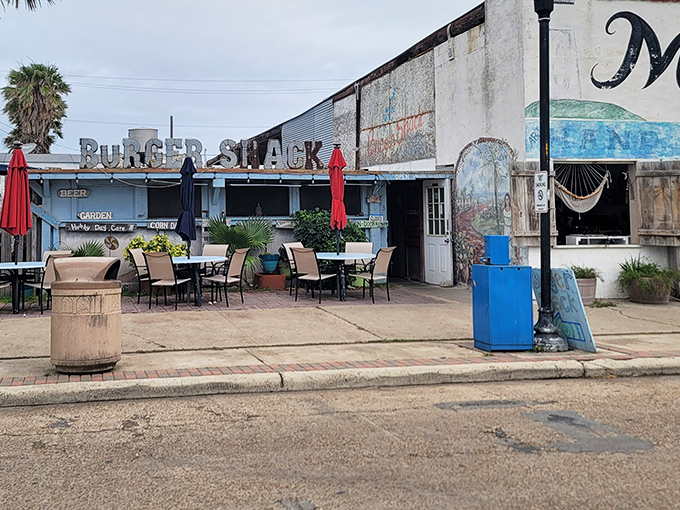 The weathered blue facade of Burger Shack speaks volumes: great food doesn't need fancy packaging, just a Gulf breeze and hungry customers.