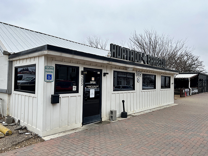 The unassuming white exterior of Hurtado Barbecue proves once again that in Texas, the most spectacular barbecue often hides in plain sight.
