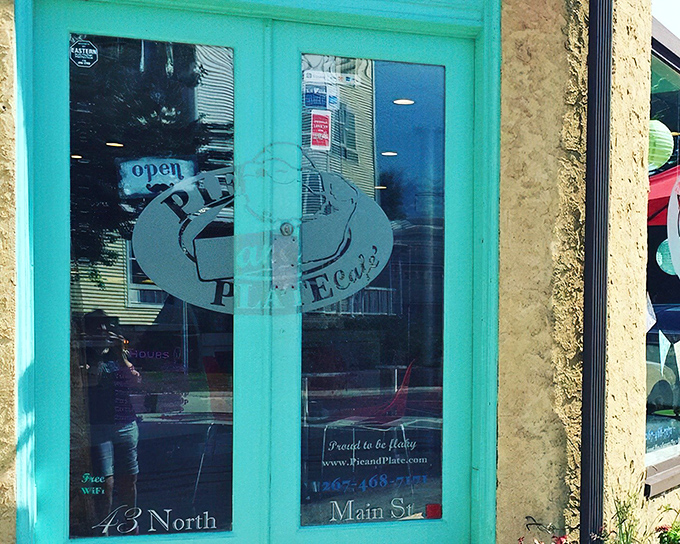 Corner charm at its finest! Pie and Plate Cafe's inviting exterior with turquoise door and bright red chairs beckons pie enthusiasts from Ambler's bustling streets.