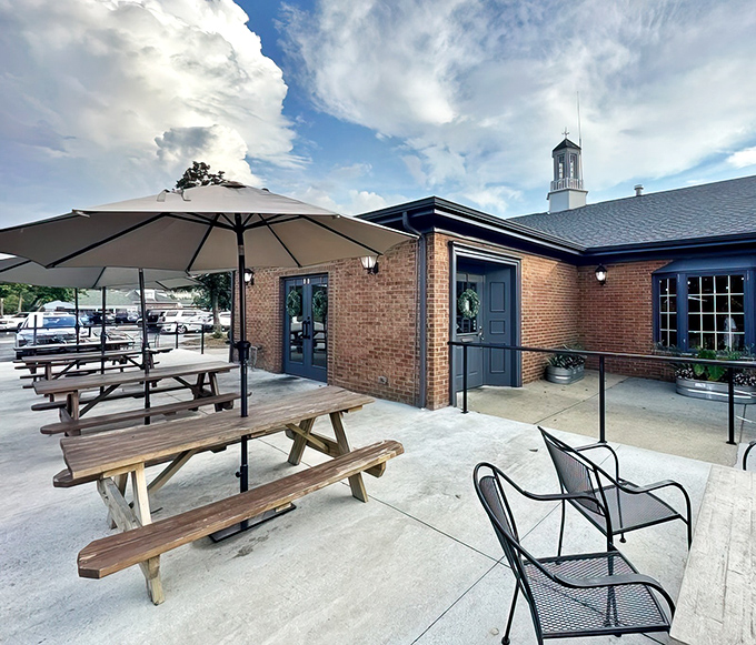Sunny skies and wooden picnic tables invite you to relax and enjoy a comfortable outdoor meal under the shaded umbrellas.