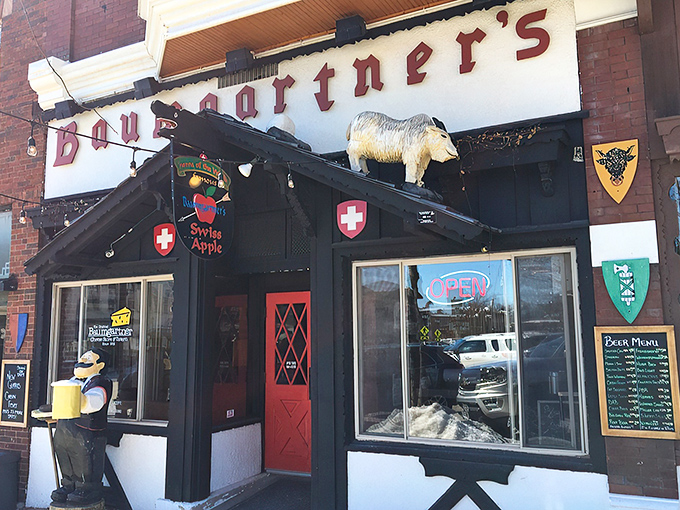 The iconic goat statue stands guard atop Baumgartner's entrance, welcoming cheese pilgrims to this Monroe landmark with quirky Wisconsin charm.