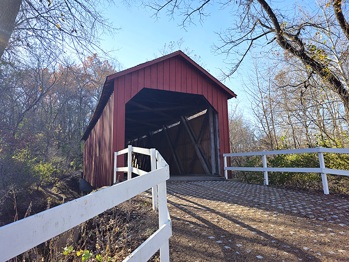 The classic red exterior of Sandy Creek Covered Bridge stands like a portal to the past, complete with white railings guiding visitors into Missouri's rural history.