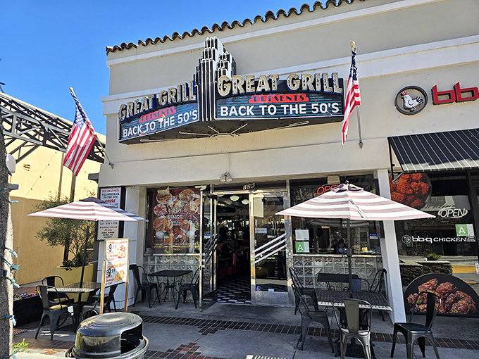 The iconic fa&ccedil;ade of The Great Grill beckons with its neon promise of time travel. American flags flutter alongside a menu that makes decisions deliciously difficult.