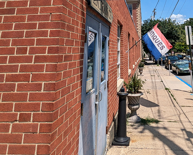 The unassuming brick exterior of Bedford Street Antiques betrays nothing of the wonderland within. That "ANTIQUES" flag is the understated invitation to a time-traveling adventure.