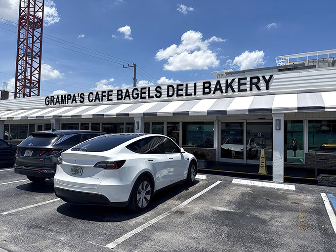The classic black-and-white striped awning isn't just retro charm&mdash;it's a beacon for bagel lovers across South Florida. Grampa's exterior promises New York authenticity under swaying palm trees.
