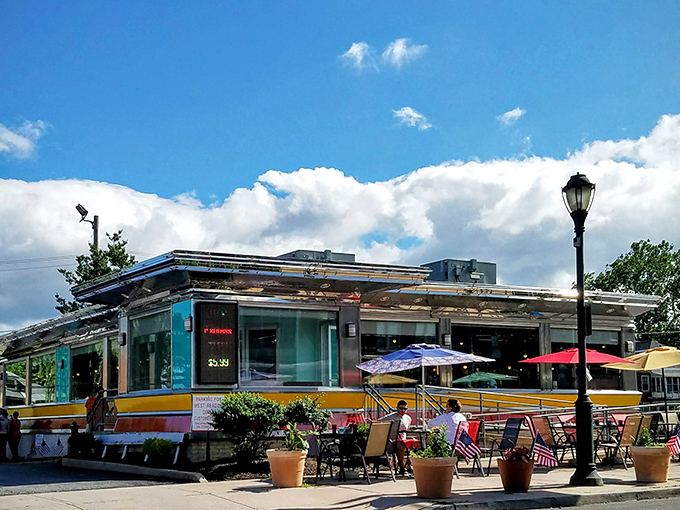 The American Diner glows like a neon-lit beacon against the twilight sky, promising comfort and calories in equal measure.