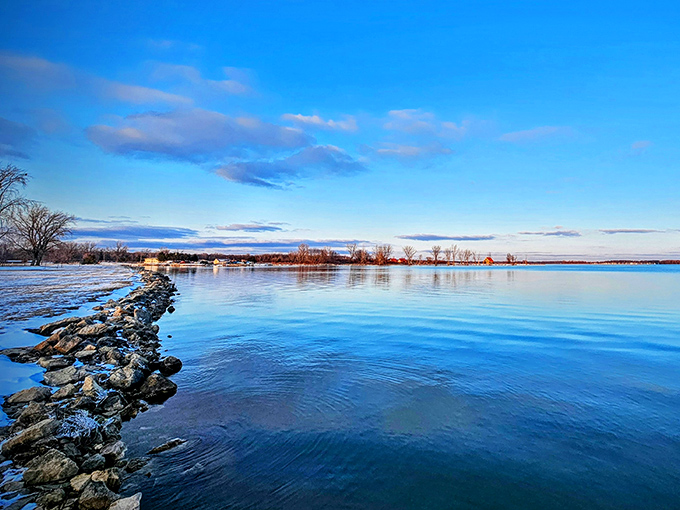 Nature's perfect mirror: this stone pathway stretches into Indian Lake's crystal waters, inviting explorers to venture just a bit further into the blue beyond.