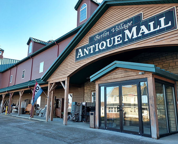 The rustic charm of Berlin Village Antique Mall beckons treasure hunters with its distinctive wooden facade and welcoming entrance, promising adventures in nostalgia inside.