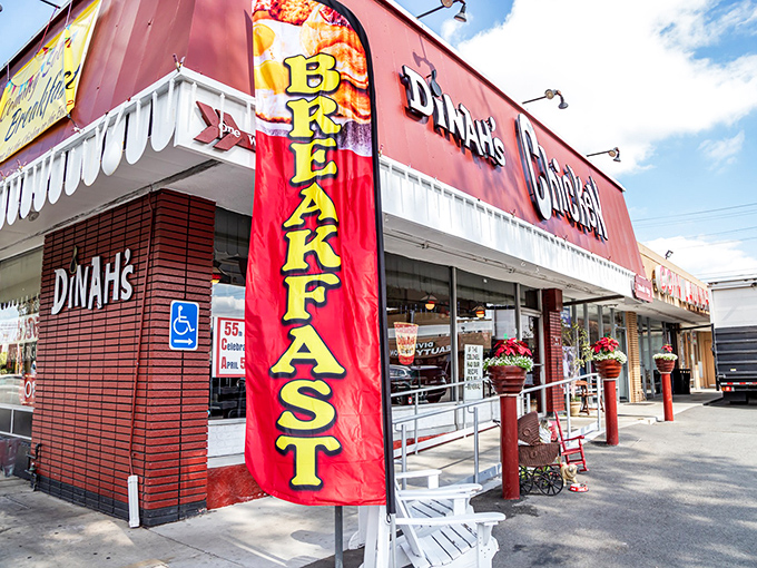 The bright red facade of Dinah's Chicken stands as a beacon of comfort food, complete with rocking chairs that invite you to slow down before the feast begins.
