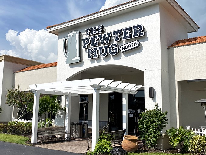 The peachy-salmon exterior of The Pewter Mug North stands like a culinary lighthouse amid Naples' palm trees, promising comfort and satisfaction within.