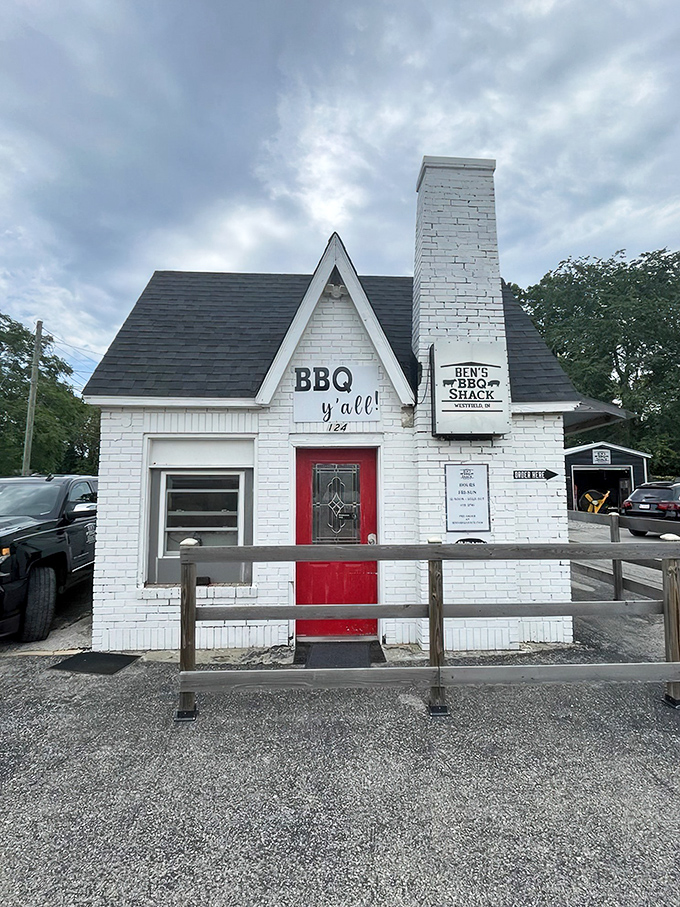 The little white house with the red door isn't a fairy tale cottage—it's something better: a temple of smoke where BBQ dreams come true.