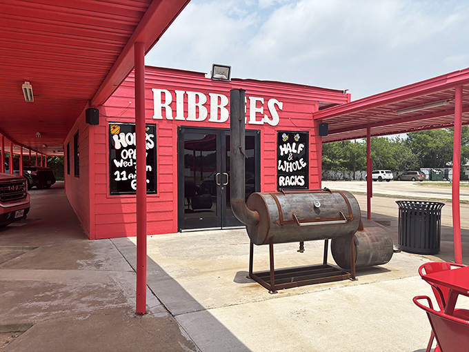 The bright red exterior of Ribbee's isn't subtle &ndash; it's like Texas itself, boldly announcing "serious barbecue happens here" with its weathered smoker standing guard.
