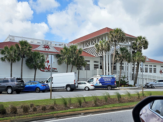 The Crab Trap stands proudly against the Florida sky, its red roof and iconic crab logo beckoning seafood lovers like a lighthouse for hungry souls.