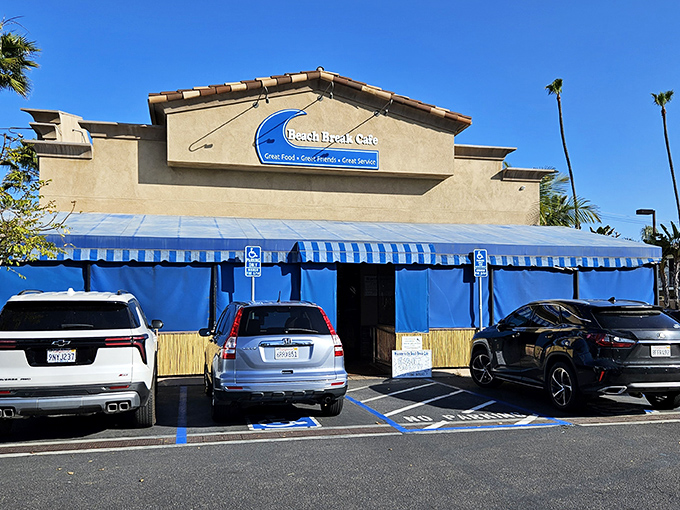 Beach Break Cafe welcomes you with its iconic blue awnings and surf-inspired signage, promising great food before you even step inside.