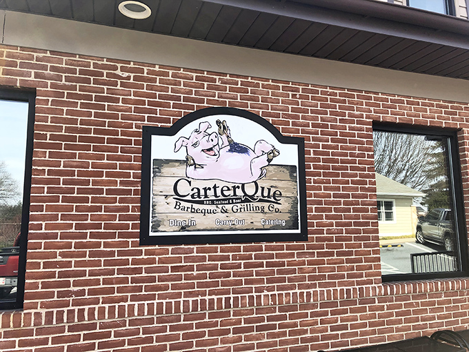 The welcoming exterior of CarterQue BBQ & Grilling Co. stands proudly in Mount Airy, where that American flag and patio practically scream "come get some smoky goodness!"