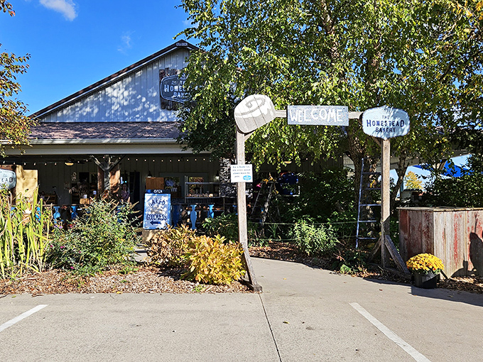 The welcoming facade of The Homestead Bakery, where colorful mums and rustic signage promise sweet treasures within. A slice of Amish country heaven awaits.