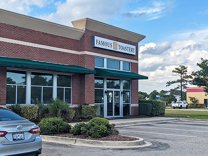 The brick facade of Famous Toastery stands like a breakfast beacon in Carolina Forest, its green awnings practically whispering "come get some eggs."