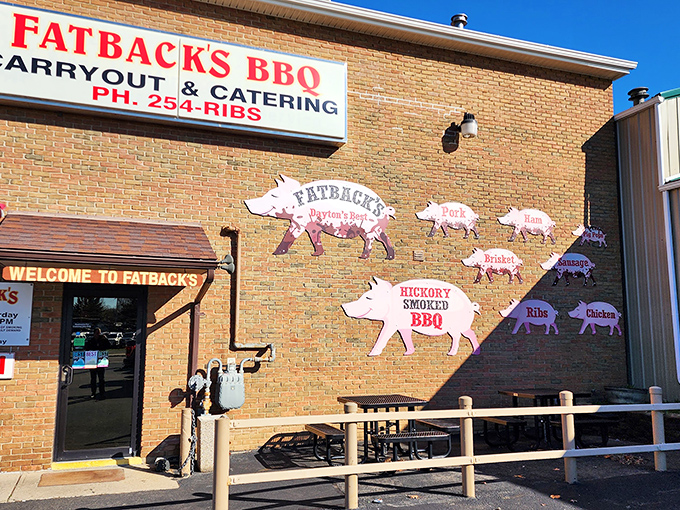 The iconic brick exterior of Fatback's BBQ, where those pig cutouts aren't just decoration&mdash;they're a roadmap to smoky paradise.