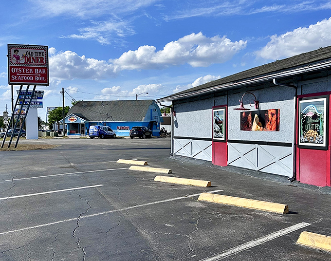 The A-frame entrance to Old Time Diner promises a journey back to simpler times, complete with checkered trim and that classic waitress logo that screams "your calories are about to have a party."